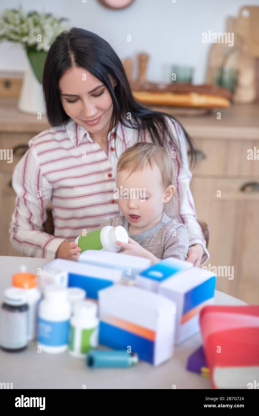 Mom and daughter sitting, holding medicine bottle Stock Photo - Alamy