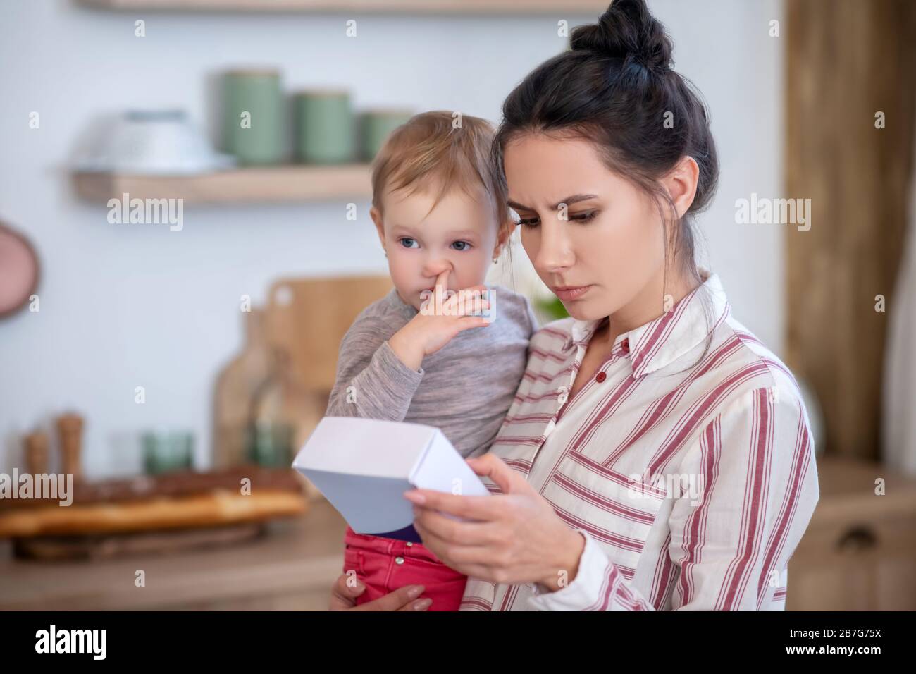 Mom reading medicine instruction, daughter poking nose Stock Photo - Alamy
