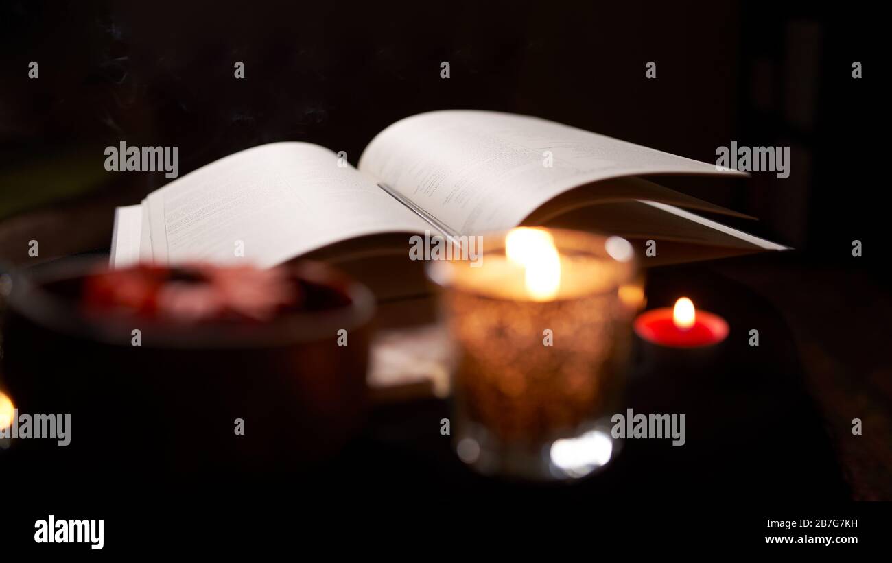Fortune teller room with open book of predictions on table with candles ...