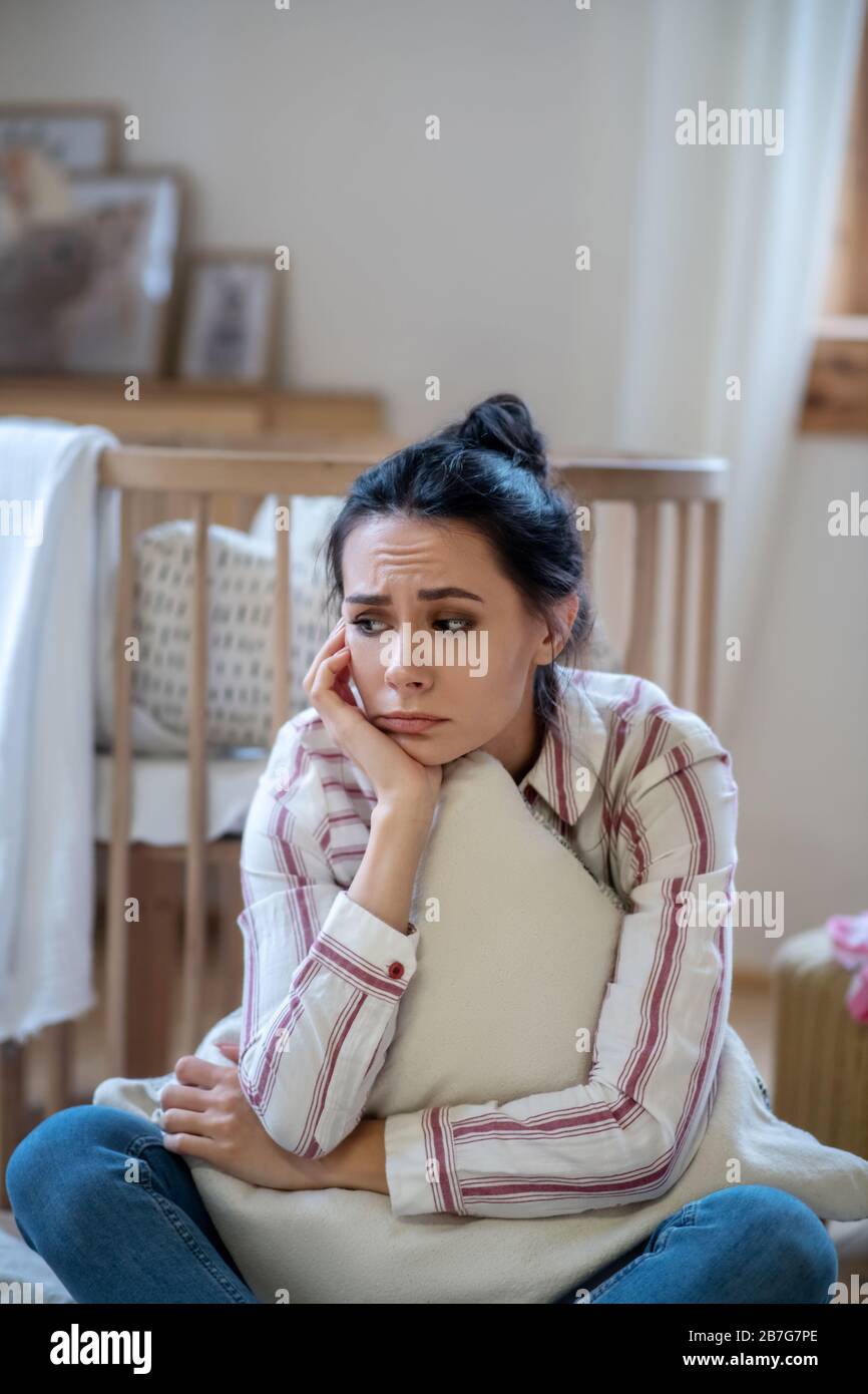 Sad young woman hugging pillow, propping up her head Stock Photo - Alamy