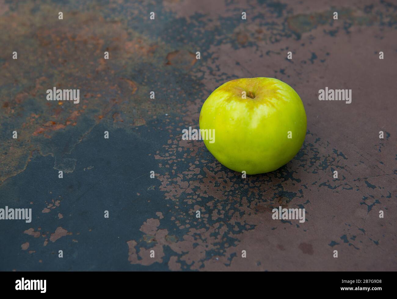 Green apple on rusty surface Stock Photo - Alamy