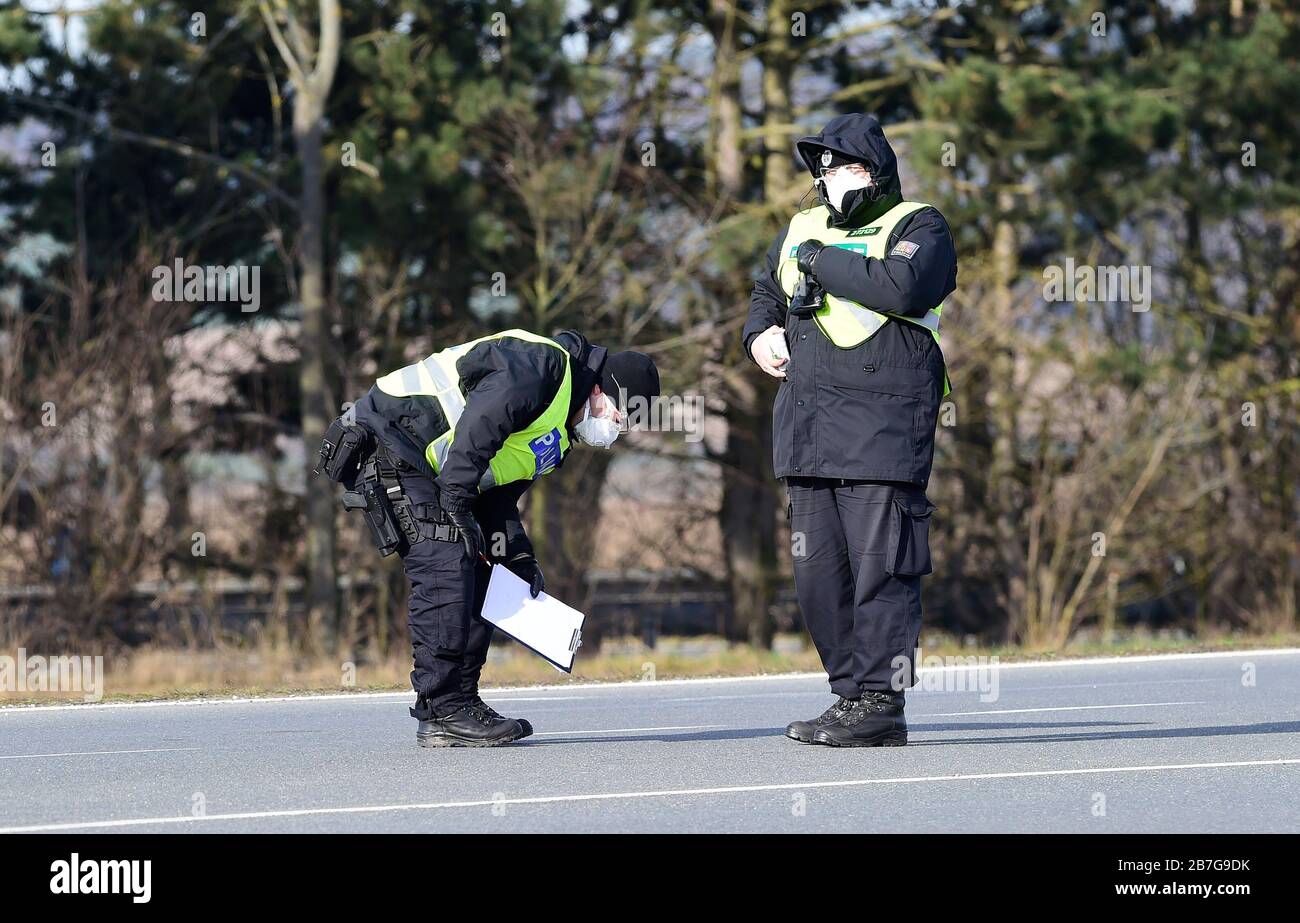 Czech police officers with respirators check vehicles passing through a ...