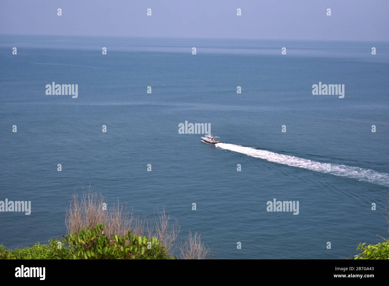 a speed boat moving forward leaving a white trail behind, far in the ...