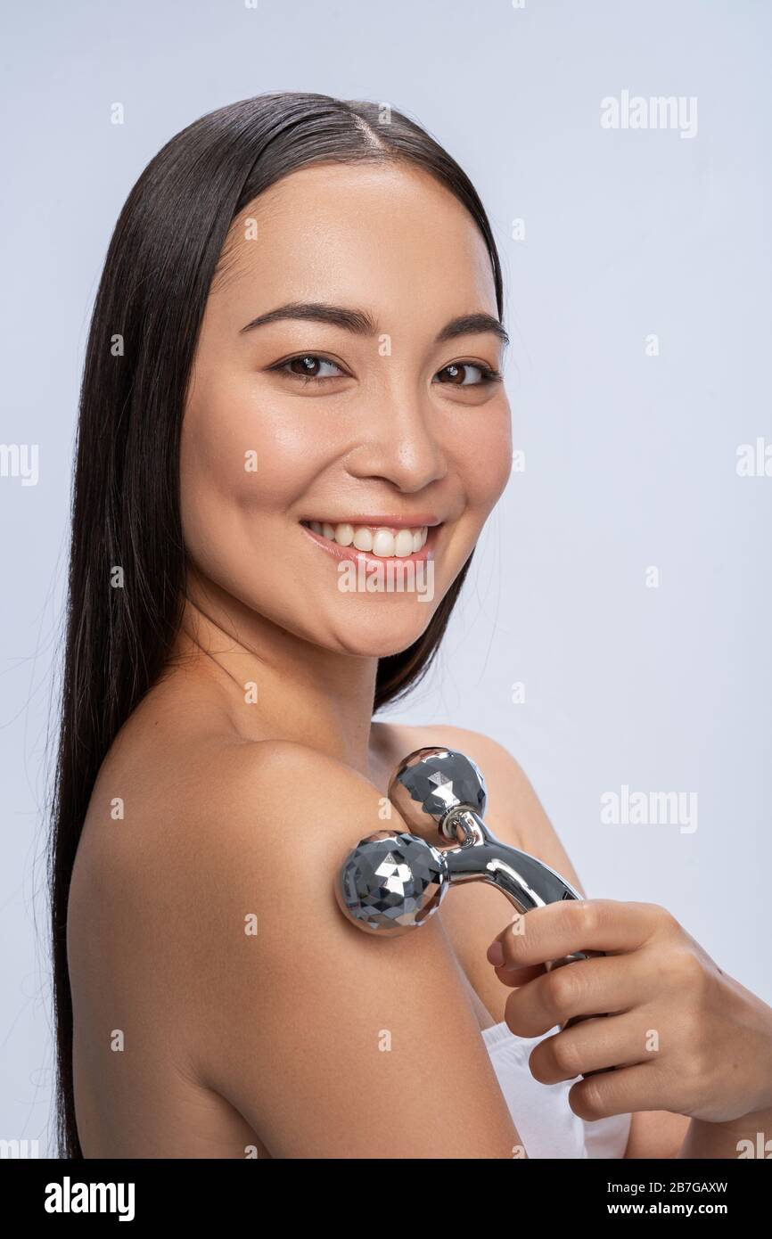 Beautiful lady getting massage face with facial roller Stock Photo - Alamy