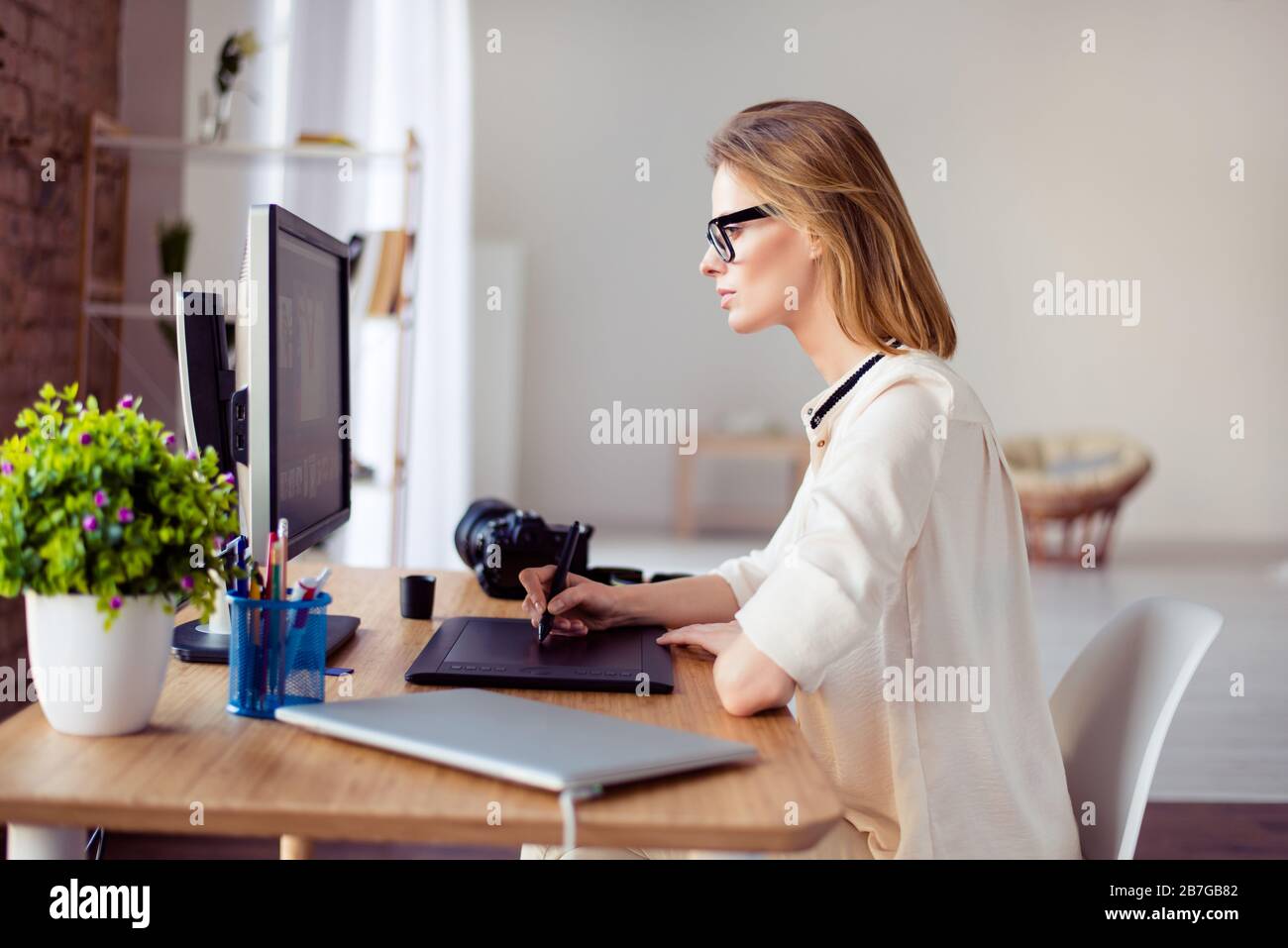 Side view of female graphic designer working with interactive pen ...