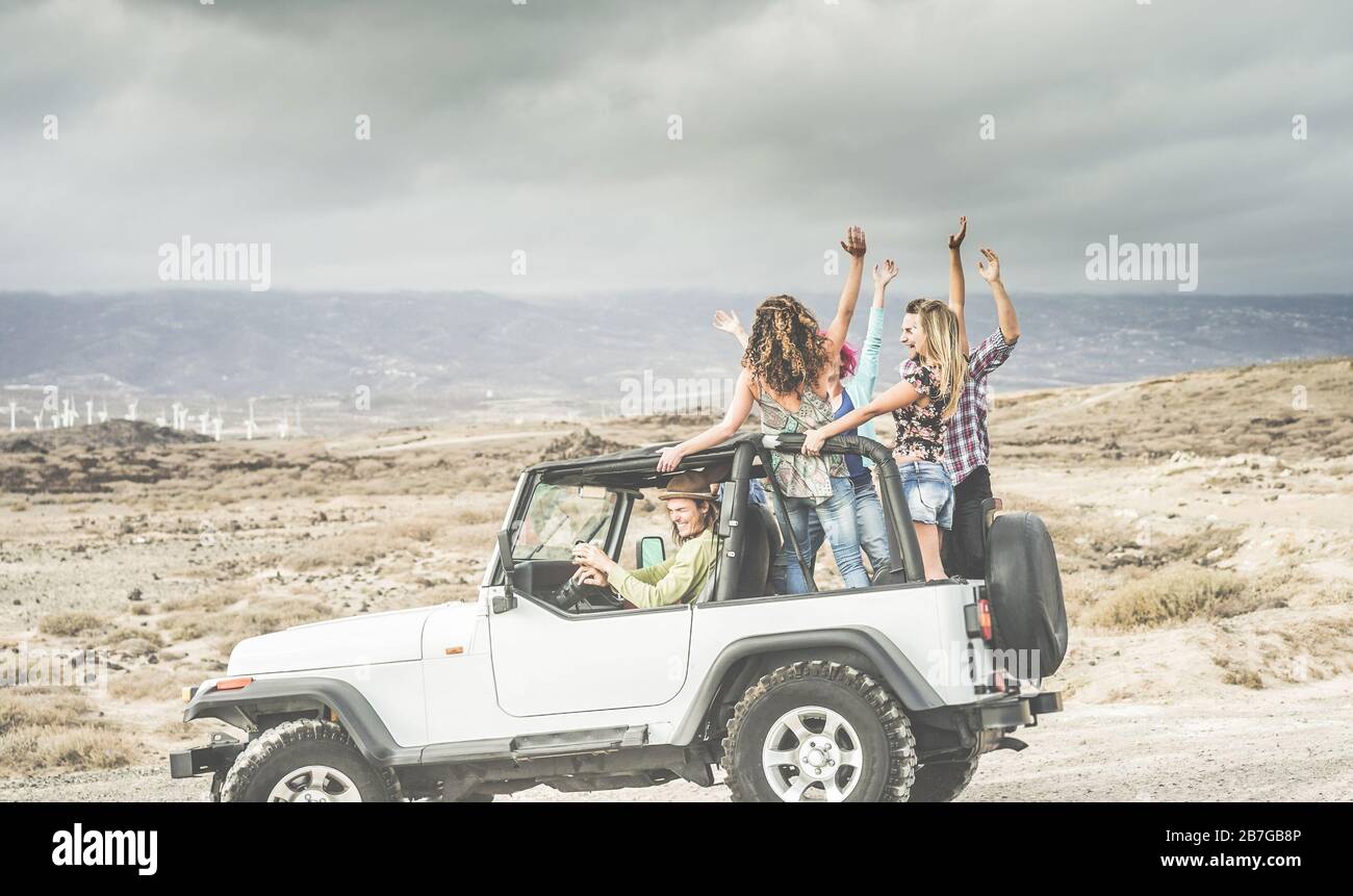Happy tourists friends doing excursion on desert in 4x4 car - Young ...