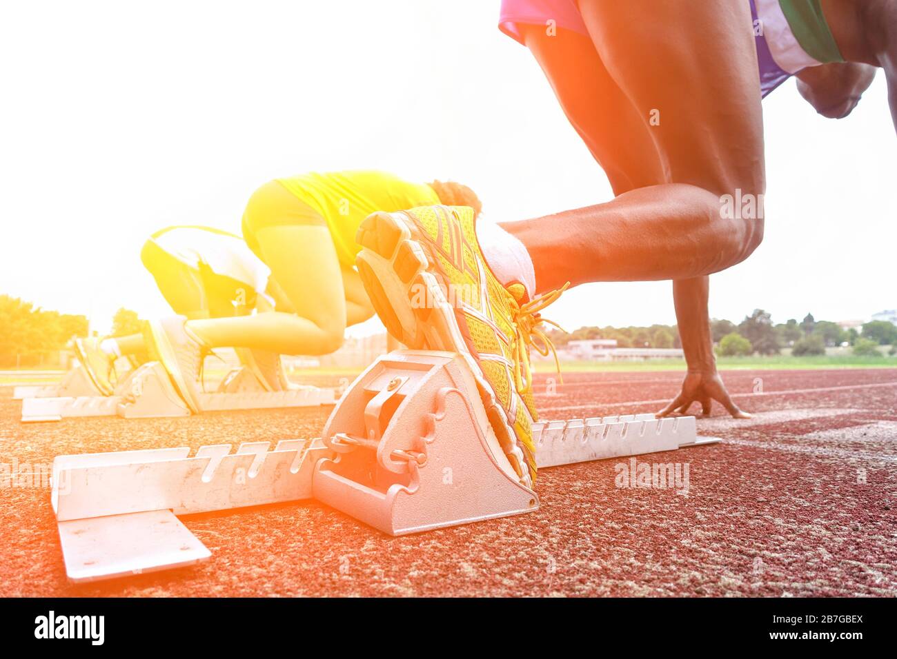 Runners feet on starting blocks in a athletic running track - Young ...