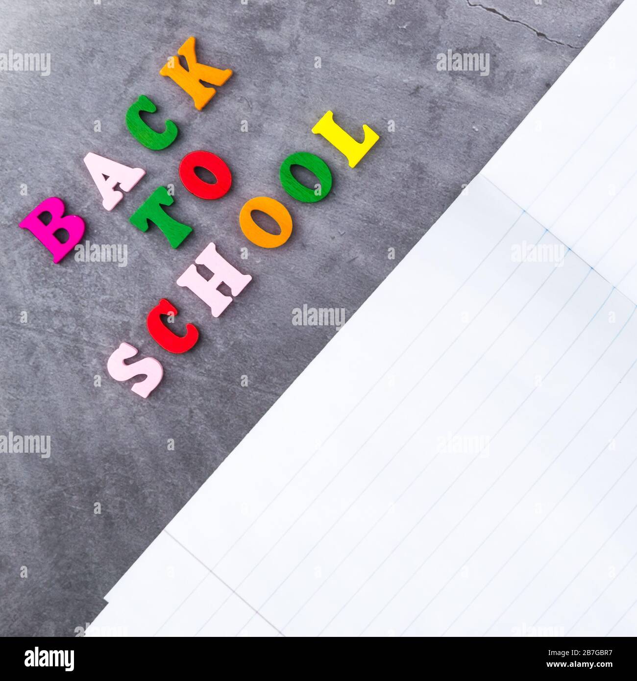 The layout of school supplies on a dark gray background. Top view, the ...