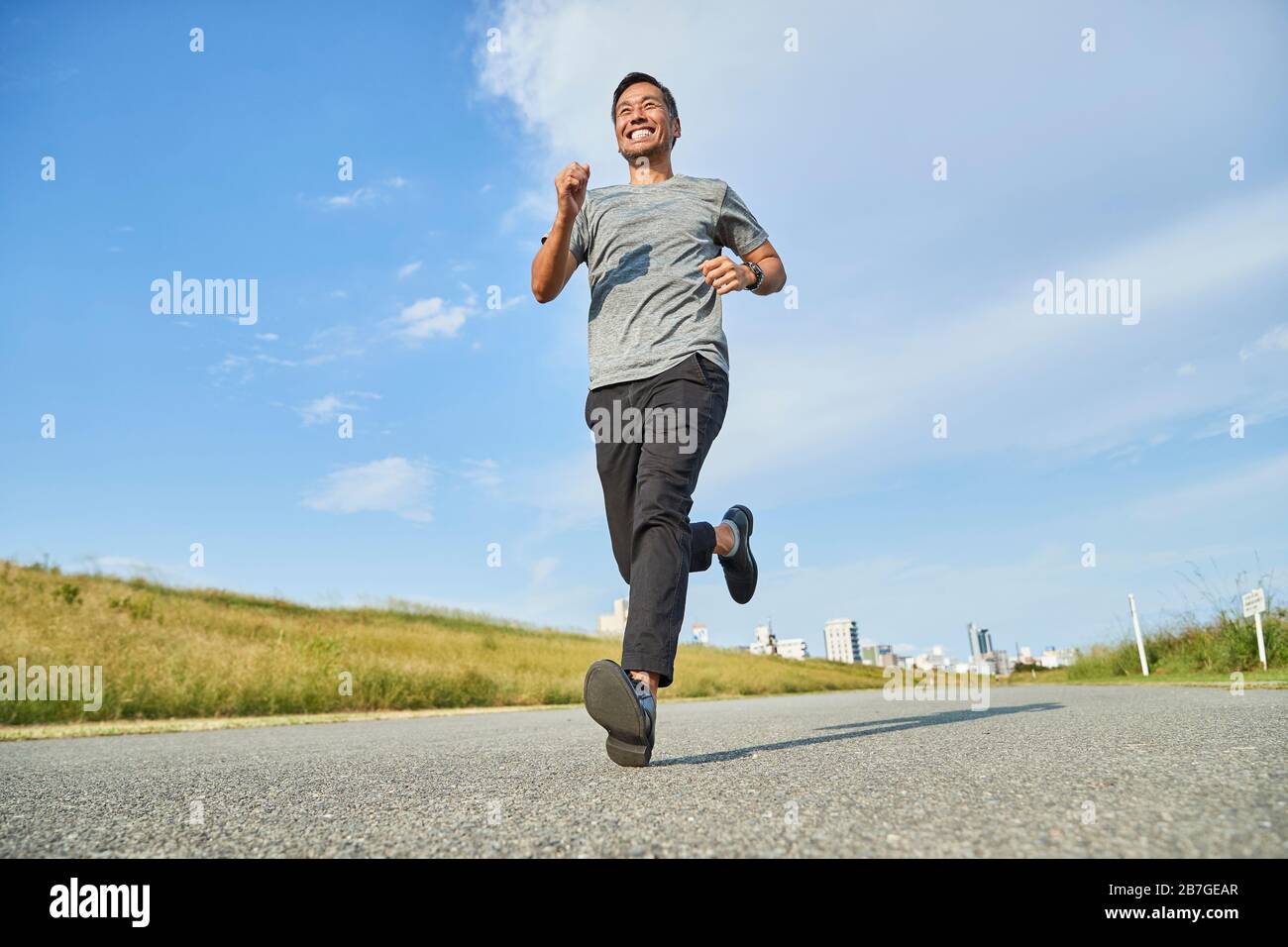 Mature Japanese man running downtown Osaka, Japan Stock Photo - Alamy