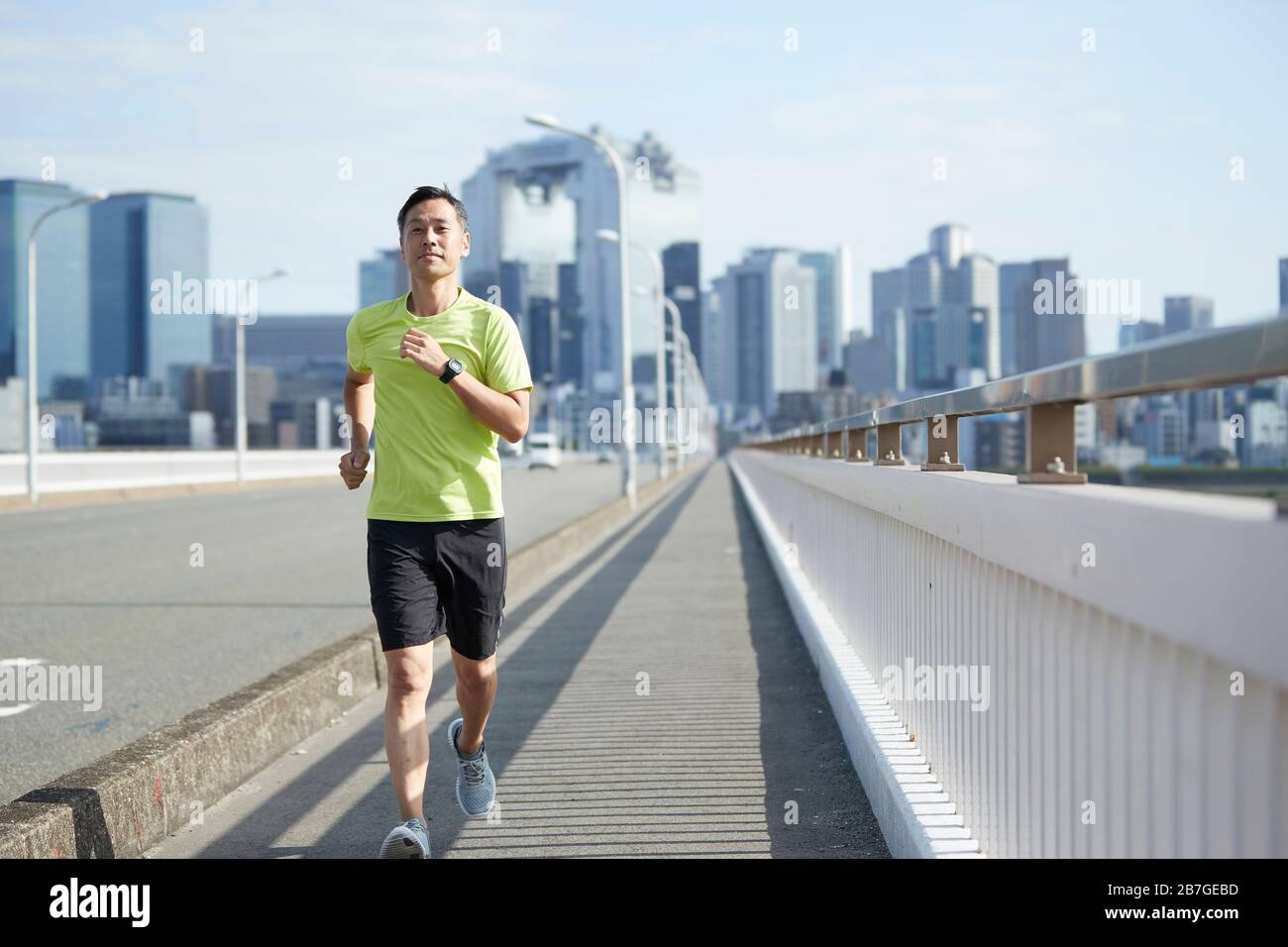 Mature Japanese man running downtown Osaka, Japan Stock Photo - Alamy