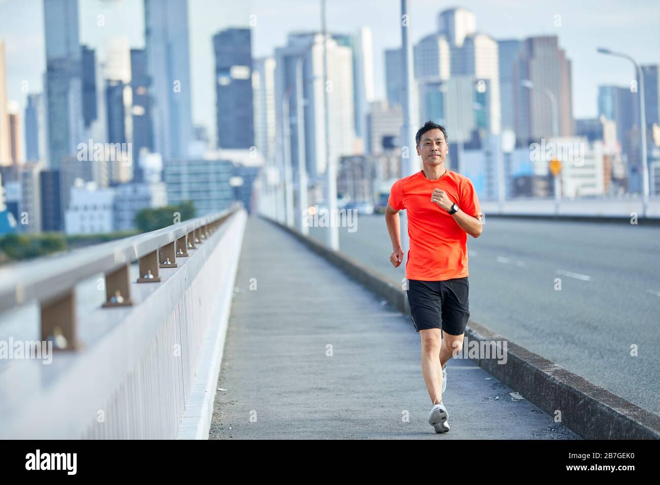 Mature Japanese man running downtown Osaka, Japan Stock Photo - Alamy