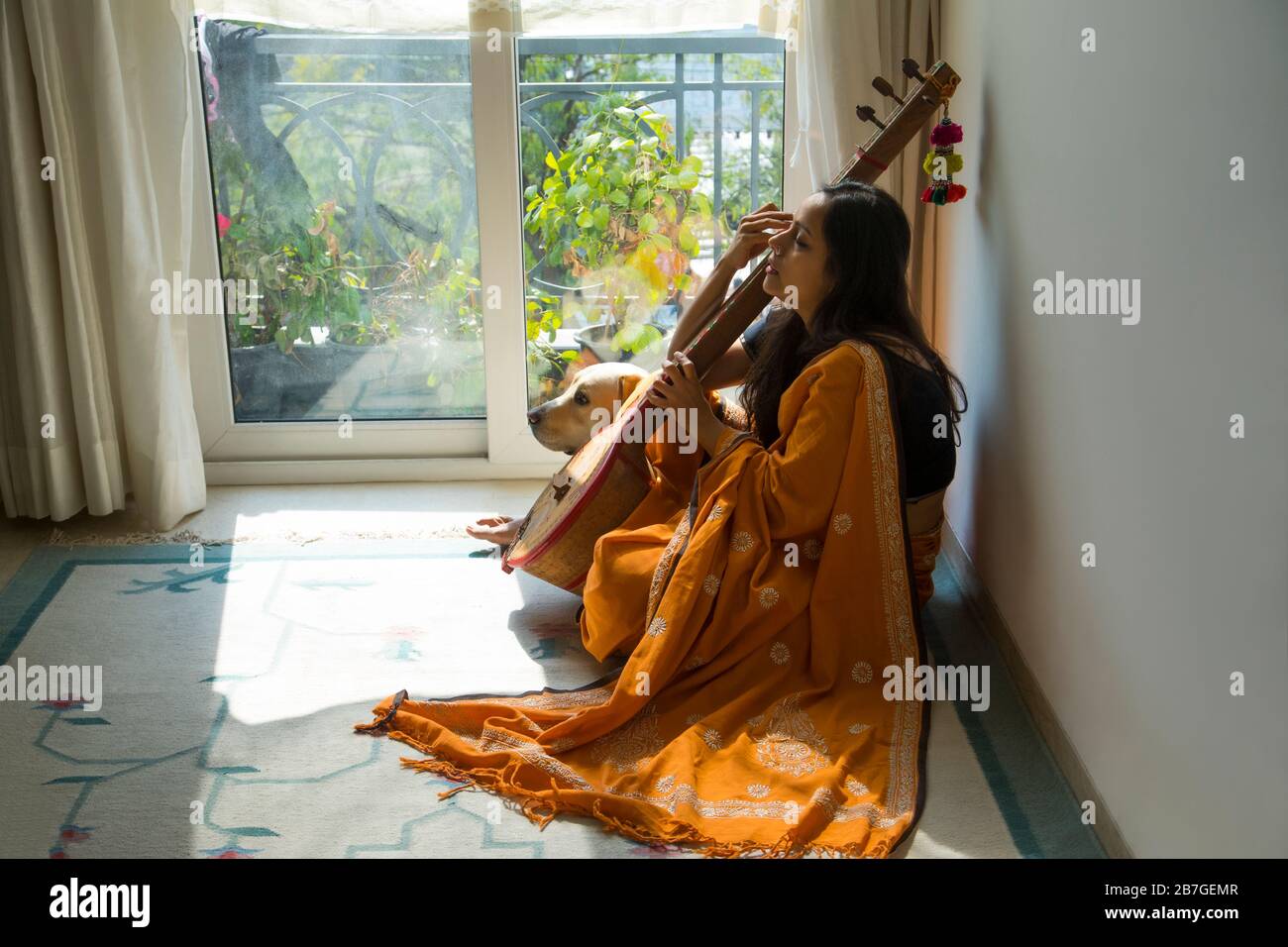 Woman sitting by the window with her tambura and singing Stock Photo ...