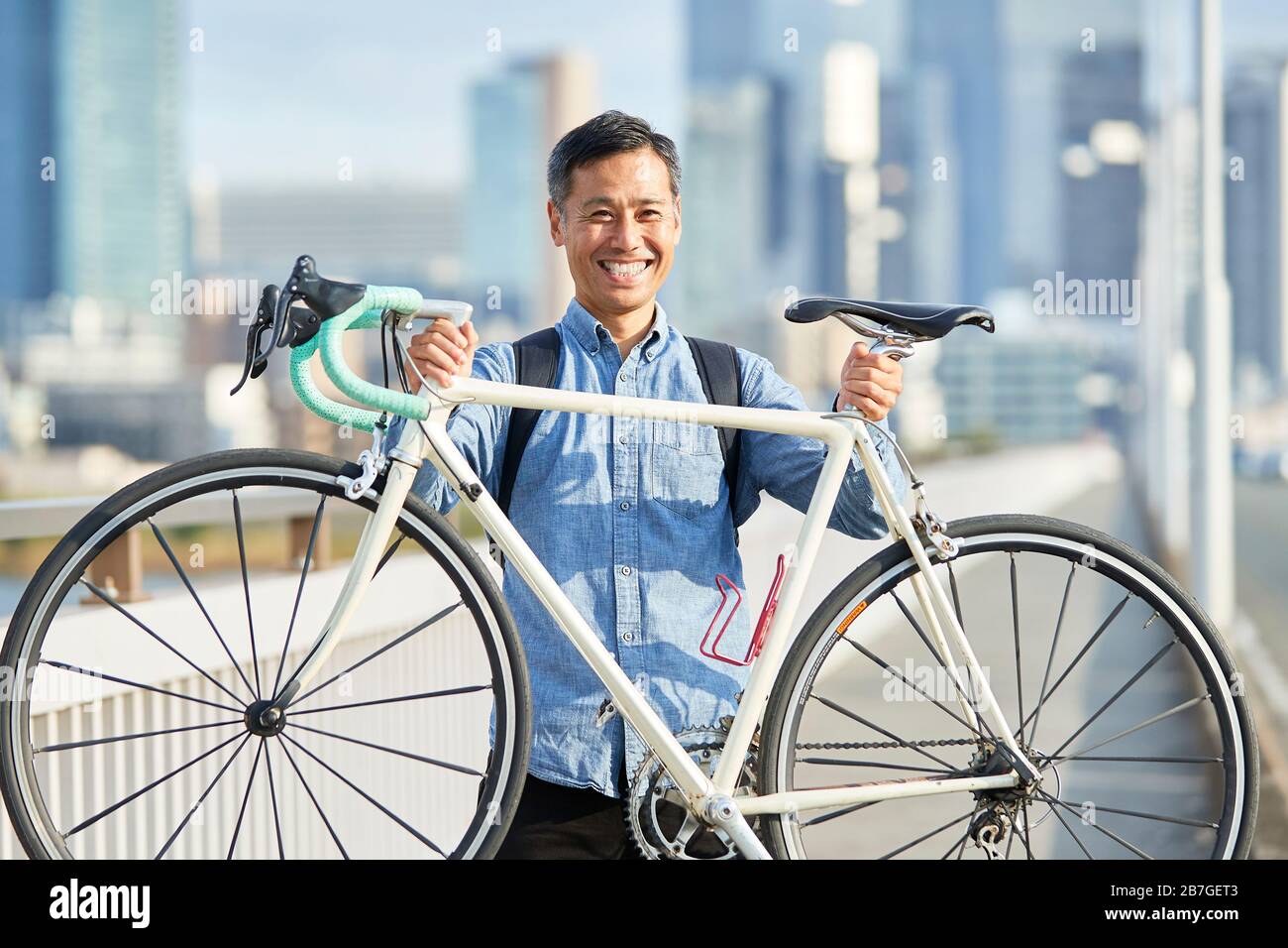 Mature Japanese man with bike downtown Osaka, Japan Stock Photo - Alamy