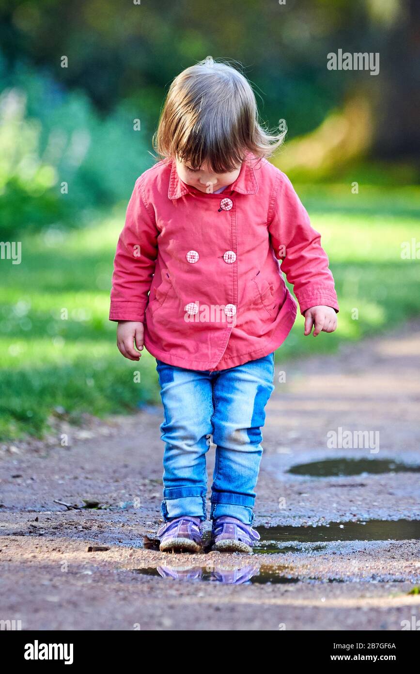 Little girl playing in a puddle Stock Photo - Alamy
