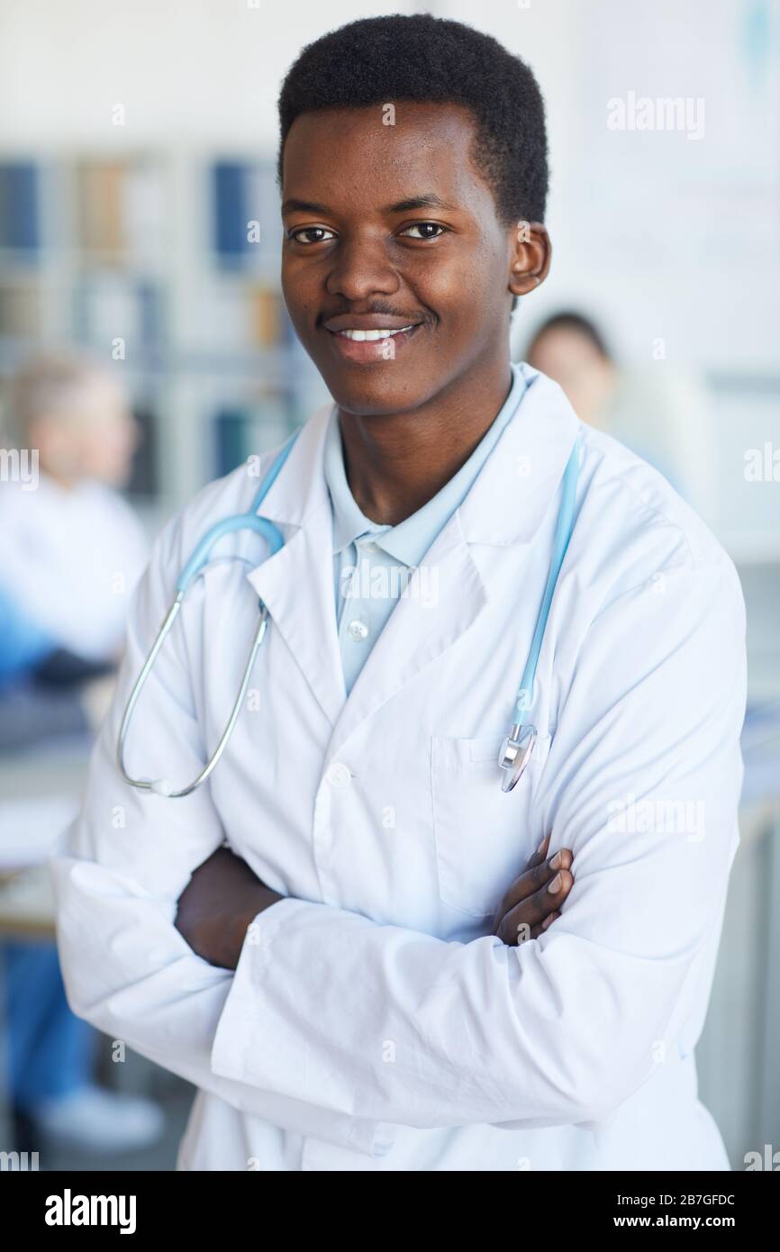Waist up portrait of young African-American doctor standing with arms ...