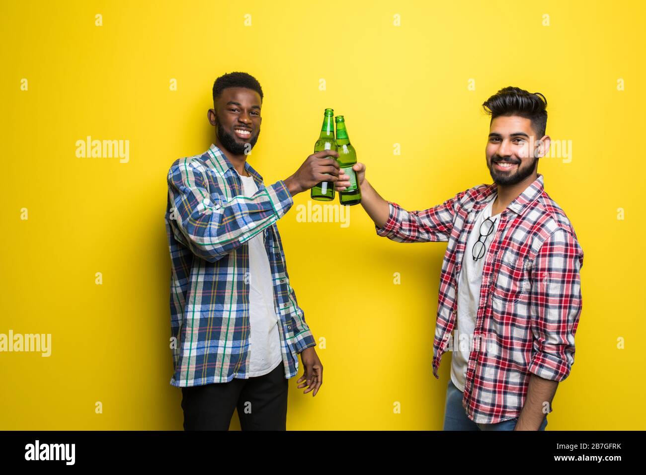 Portrait of a two cheerful young men best friends toasting with beer ...