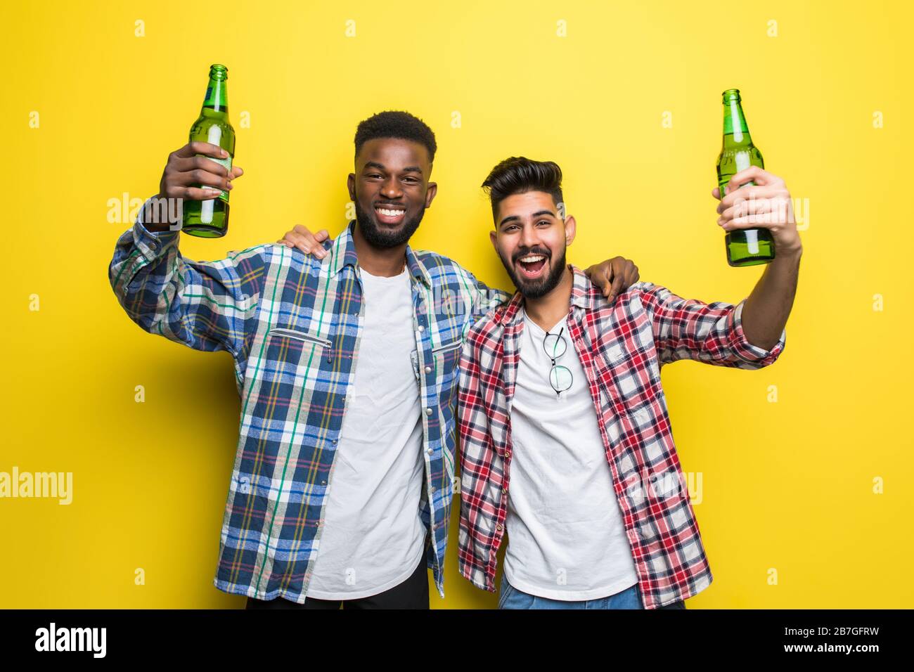 Portrait of a two cheerful young men best friends toasting with beer ...