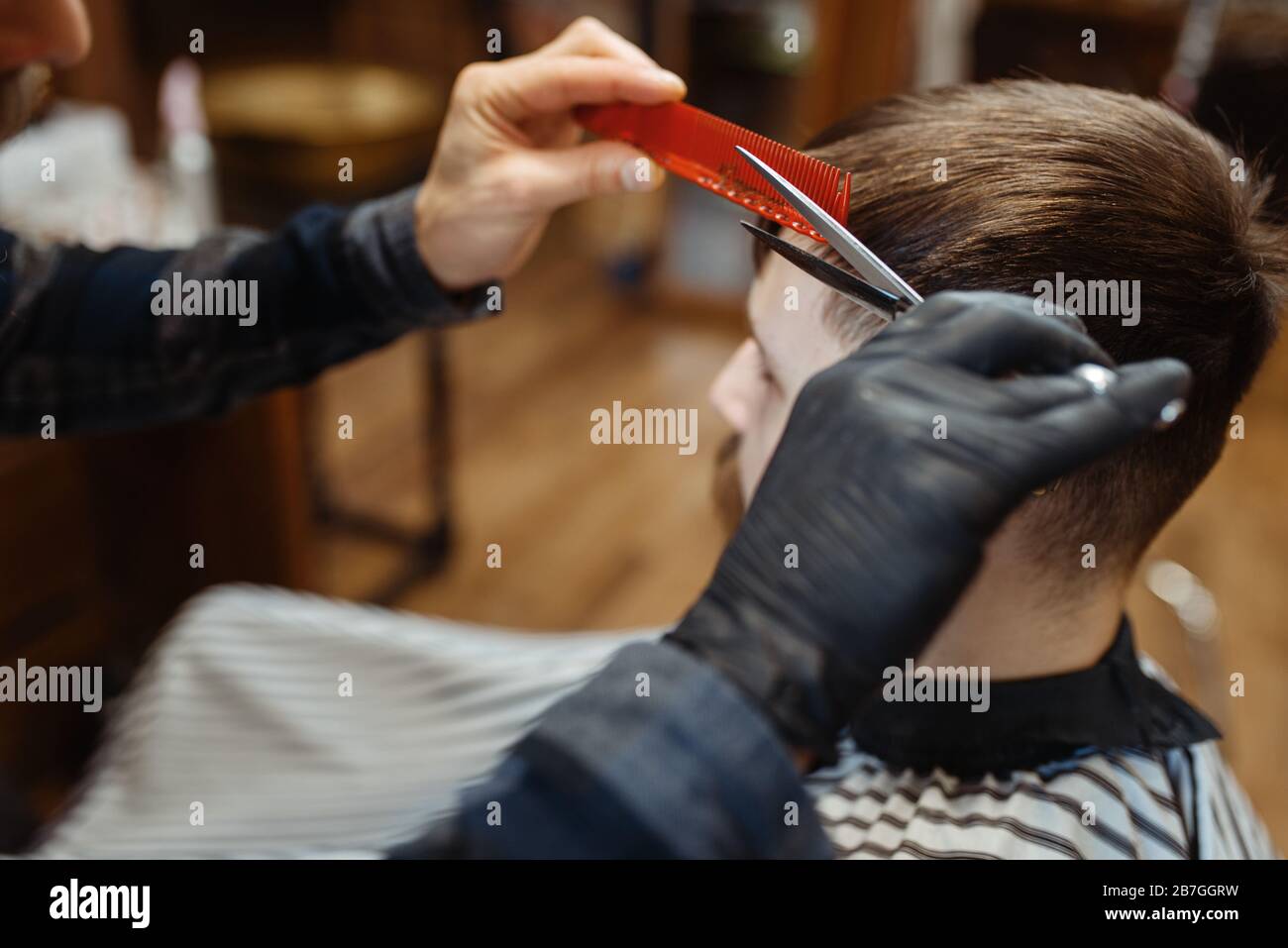 Barber with comb and scissors makes a haircut Stock Photo - Alamy