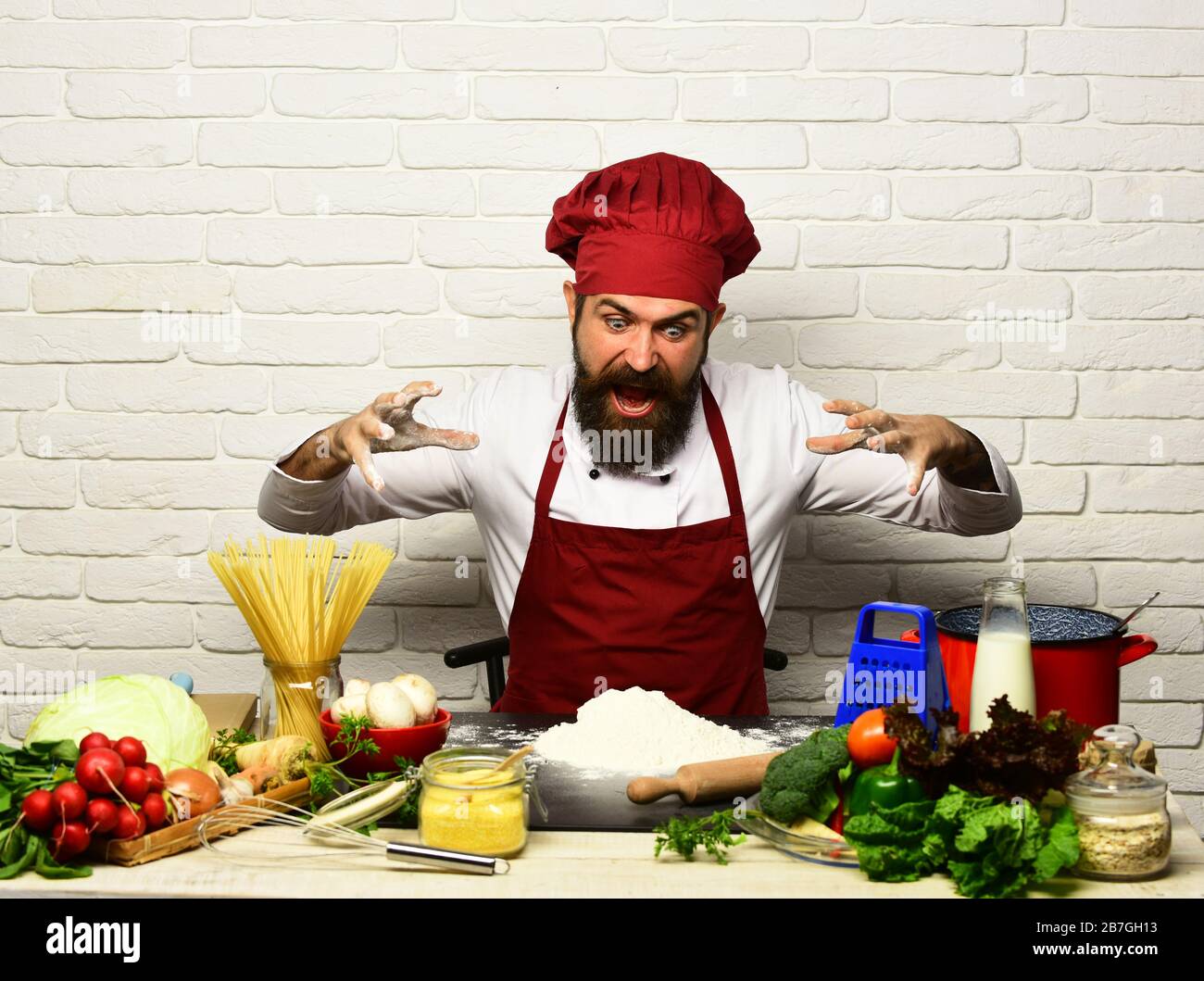 Man with beard looks scary on white brick wall background. Restaurant ...
