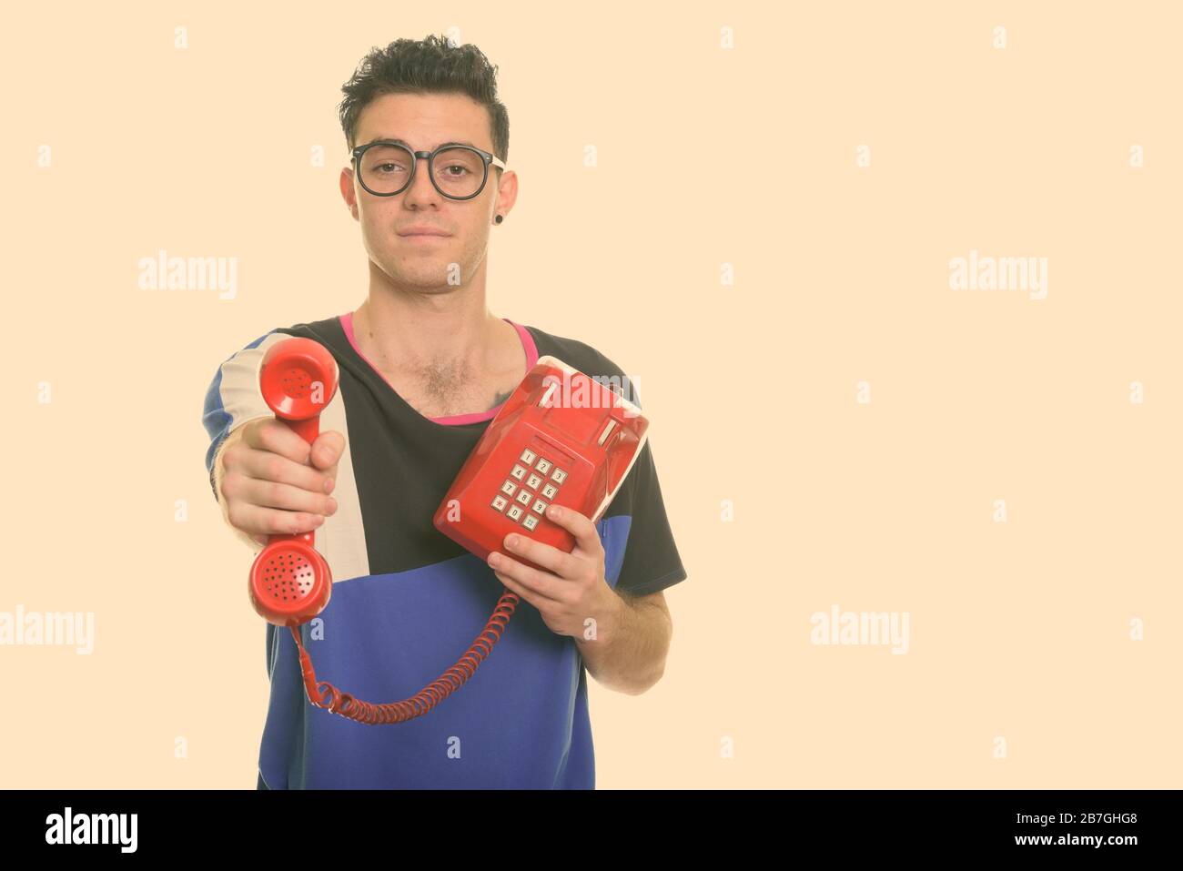 Studio shot of young man giving old telephone Stock Photo - Alamy