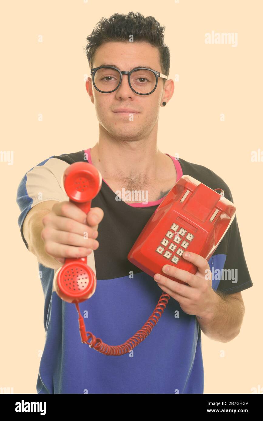 Studio shot of young man giving old telephone Stock Photo - Alamy