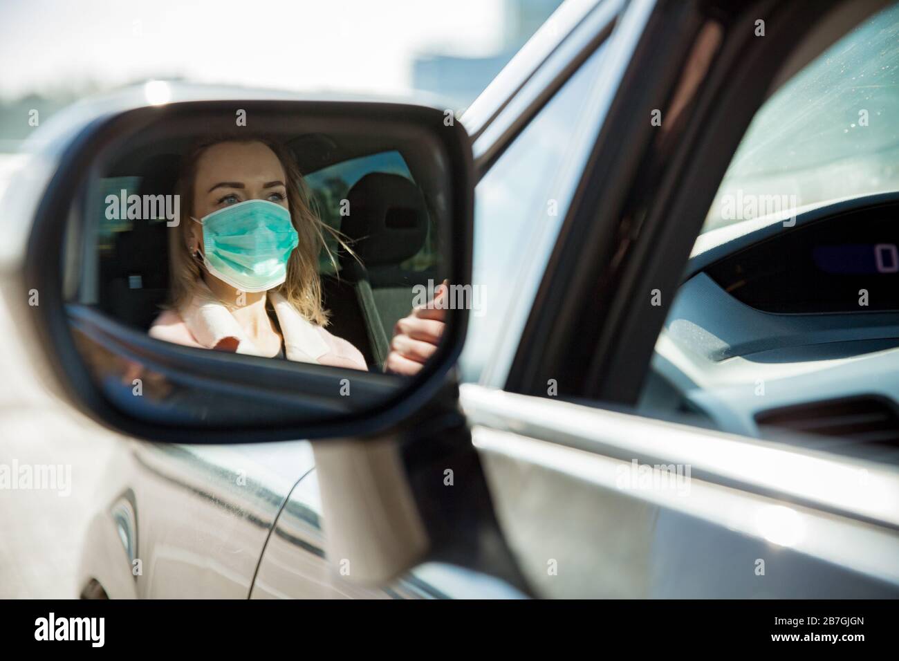 Woman in protective mask driving a car on road. Safe traveling Stock ...