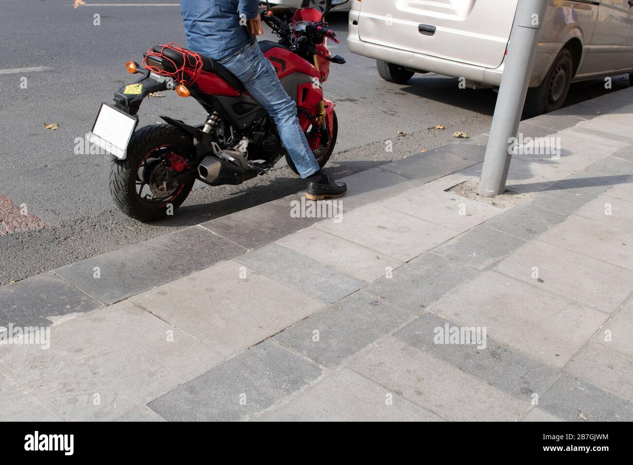 Motorcycle and driver on the roadside. The driver is waiting with his ...