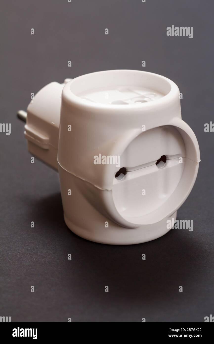 Close-up white plastic electrical tee connector with three sockets on a ...