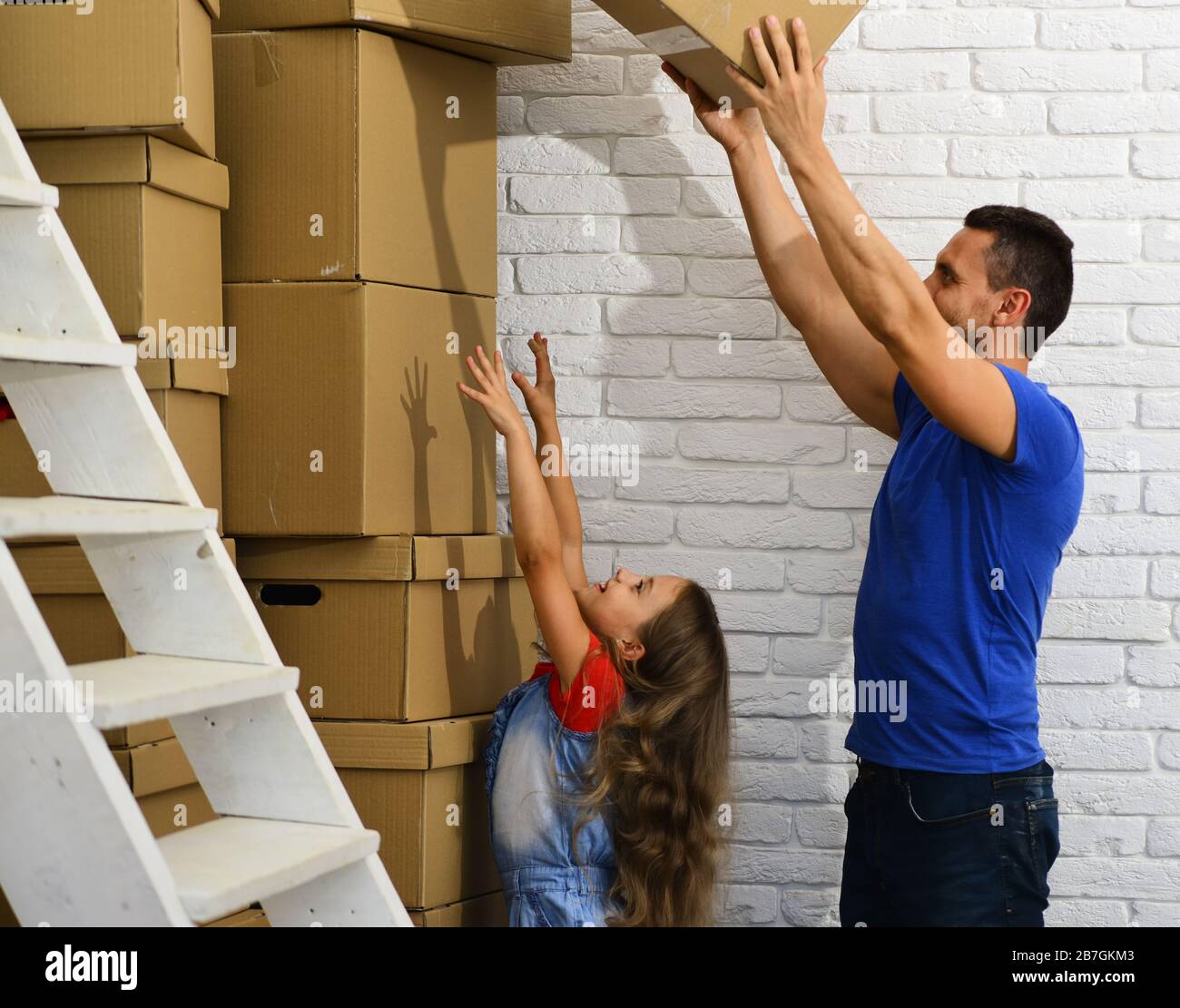 Father and child with happy faces. Dad and daughter stand by pile of ...