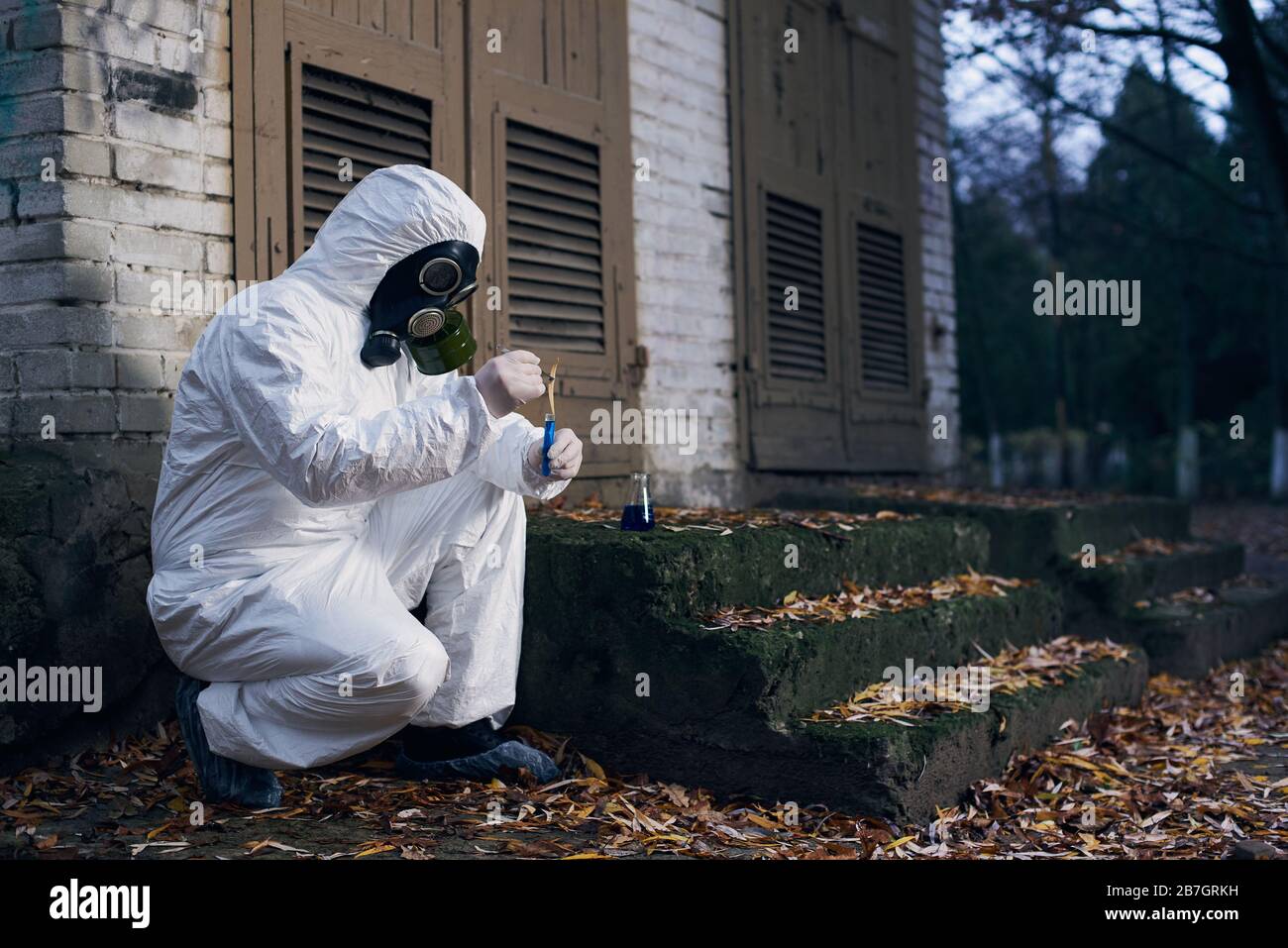 Scientist wearing protective coverall, gas mask and gloves. Worker ...