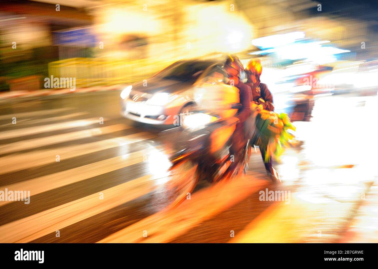 Heavy charged motorcycle with two person in night street traffic in ...