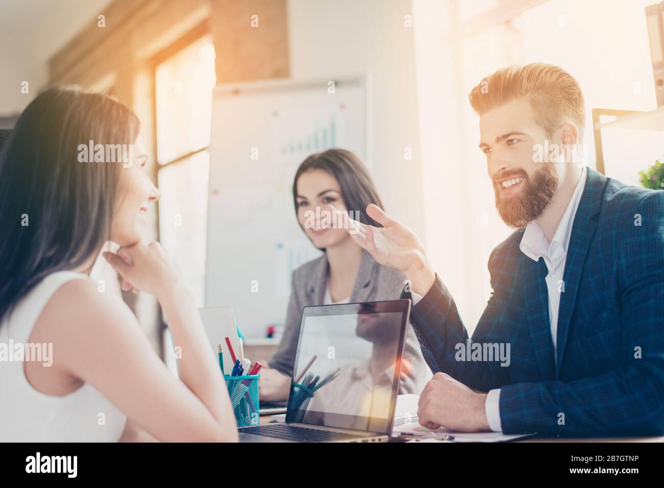 Business partners are smiling and discussing documents and ideas to ...