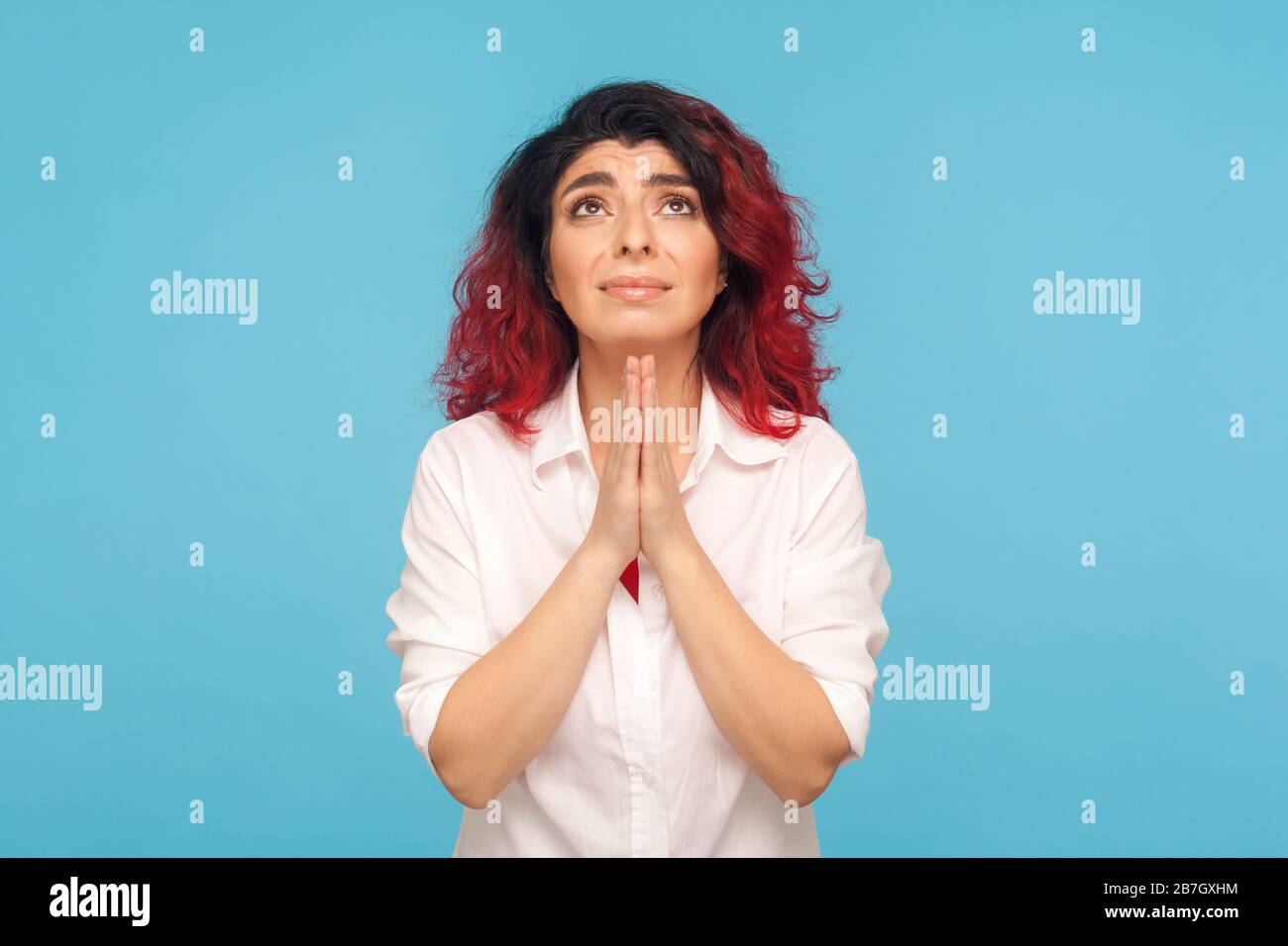 Portrait of depressed upset woman with fancy red hair holding hands in ...