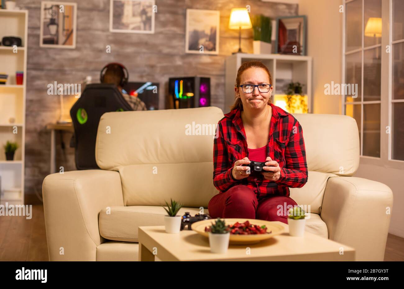 Woman gamer playing video games on the console in the living room late ...