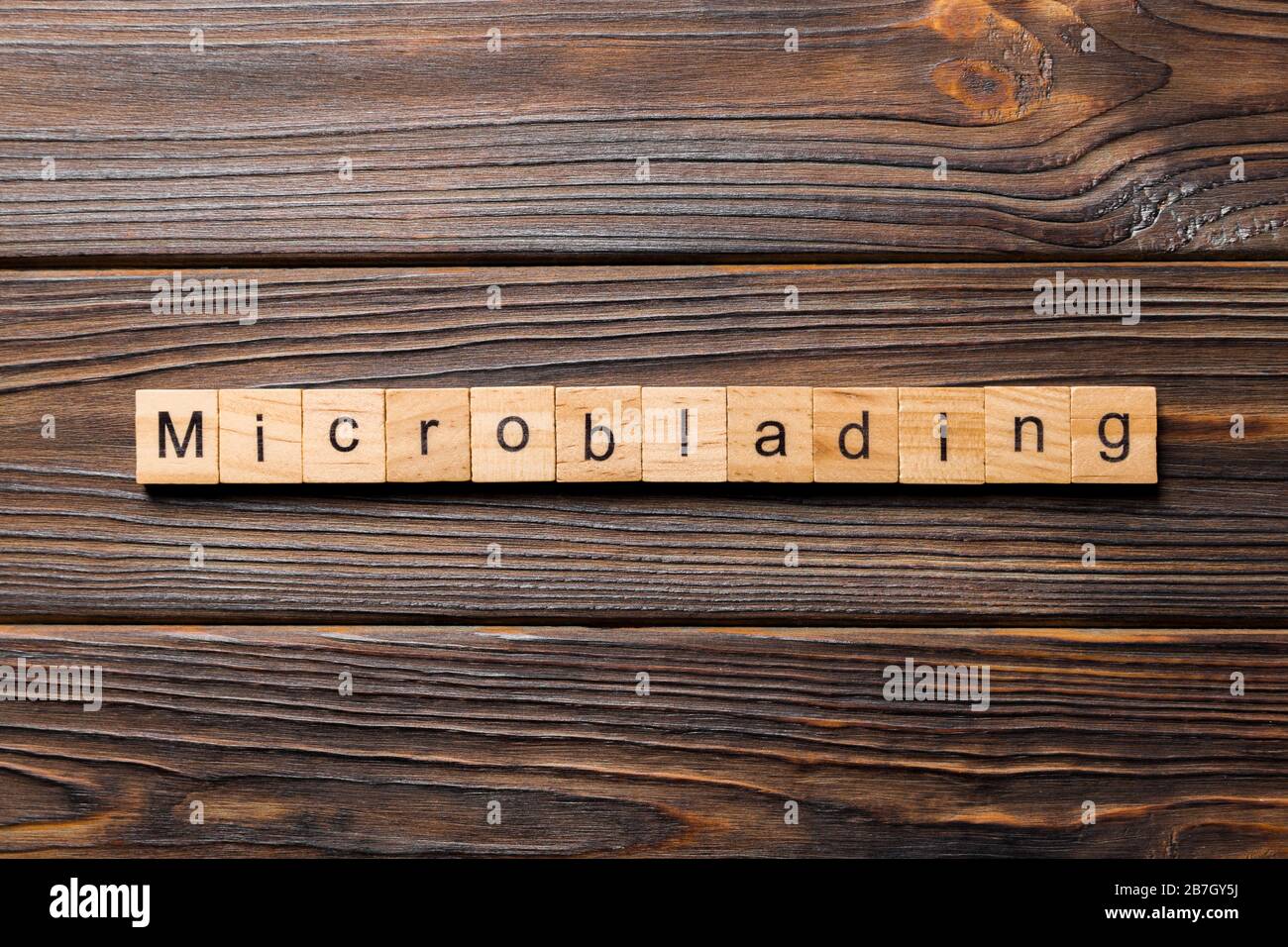 Microblading word written on wood block. Microblading text on wooden ...