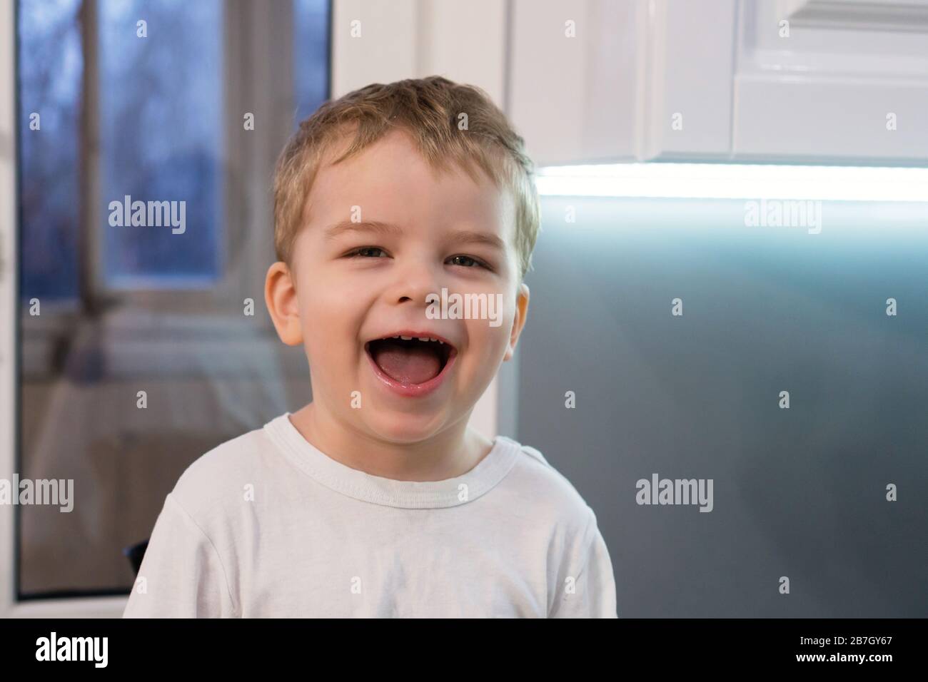 Cute emotional boy in the kitchen. Smile emotion expression portrait ...