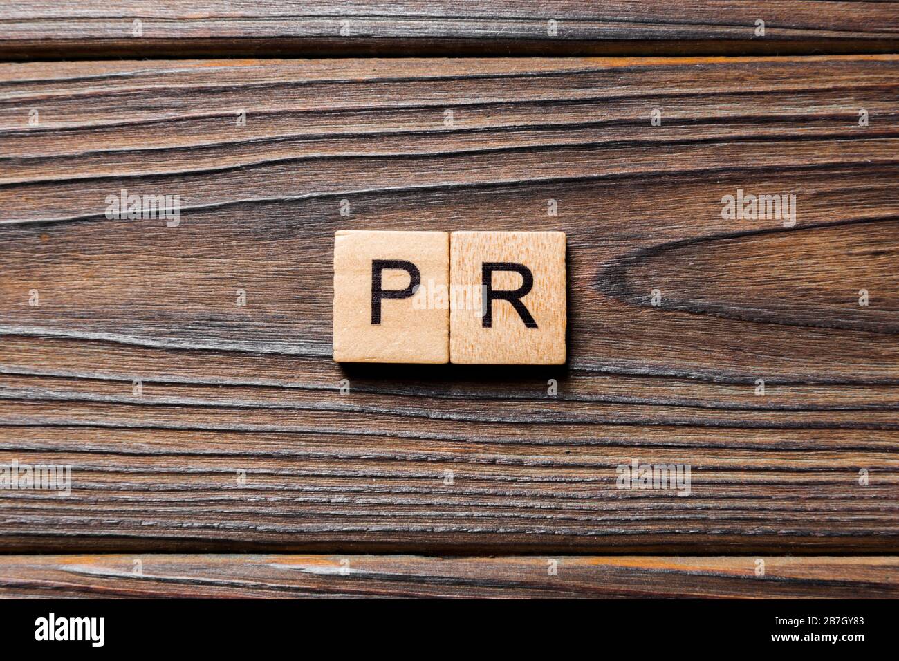 pr word written on wood block. public relation text on table, concept ...