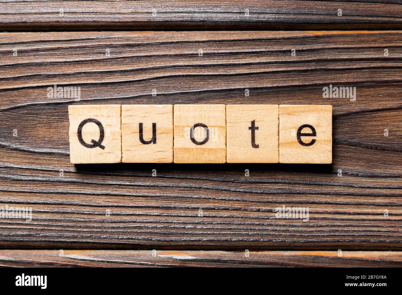 Quote word written on wood block. Quote text on wooden table for your ...