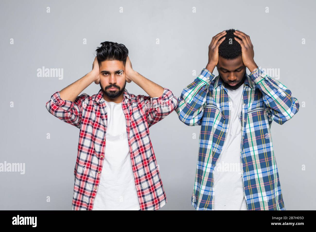 Portrait of a two sad young men lose over gray background Stock Photo ...