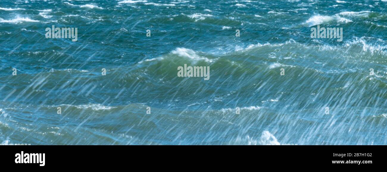 Waves hit the hard surface of concrete wall and splashing sea water ...