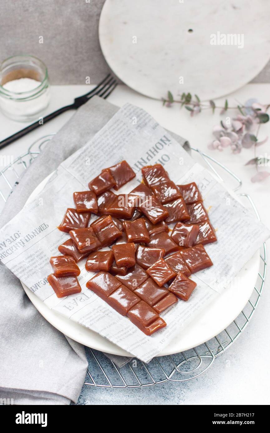 Salted caramel candies cut into square pieces, top view over grey ...