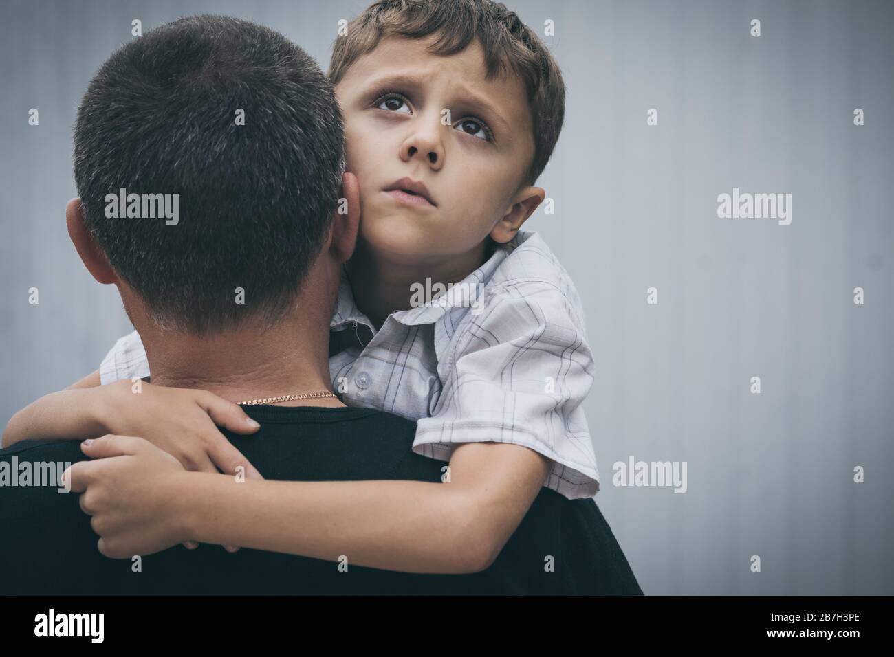 Portrait of young sad little boy and father standing outdoors at the ...