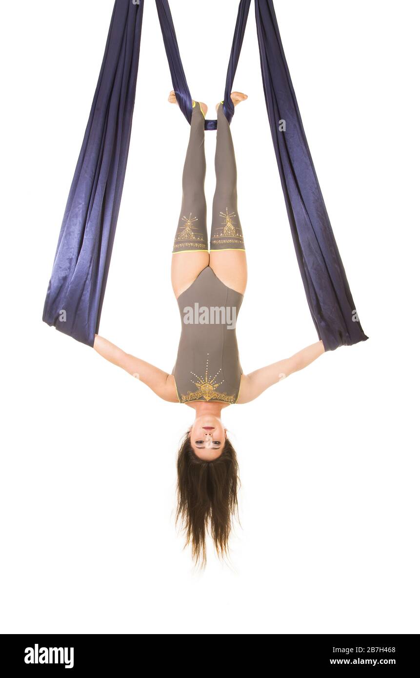 Young, smiling acrobat, with long hair, in a gray suit and leggings ...