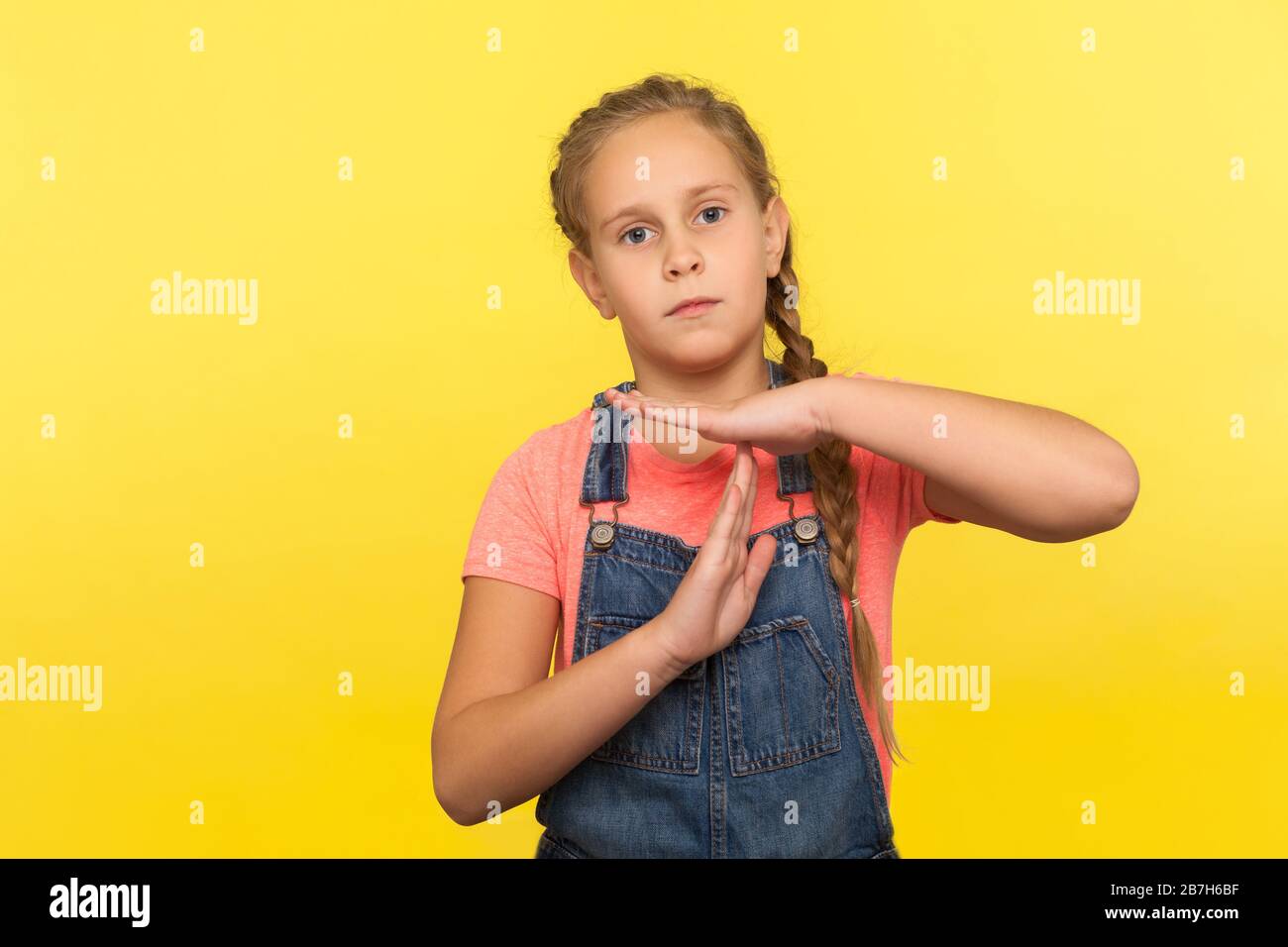Stop, limit gesture. Portrait of tired unhappy little girl with braid ...