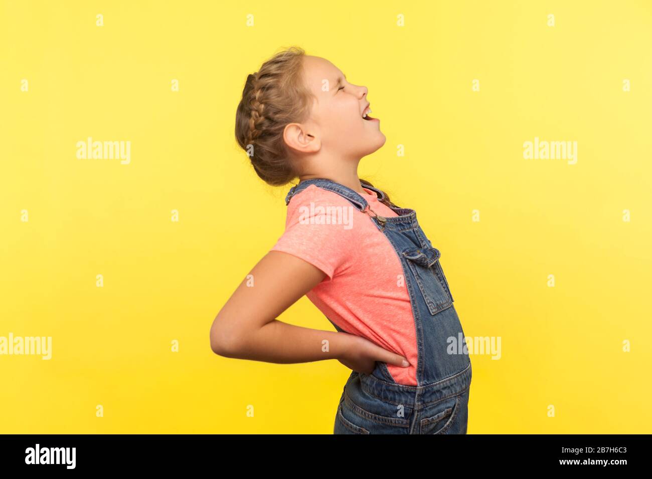Child suffering back ache. Portrait of desperate unhealthy little girl ...