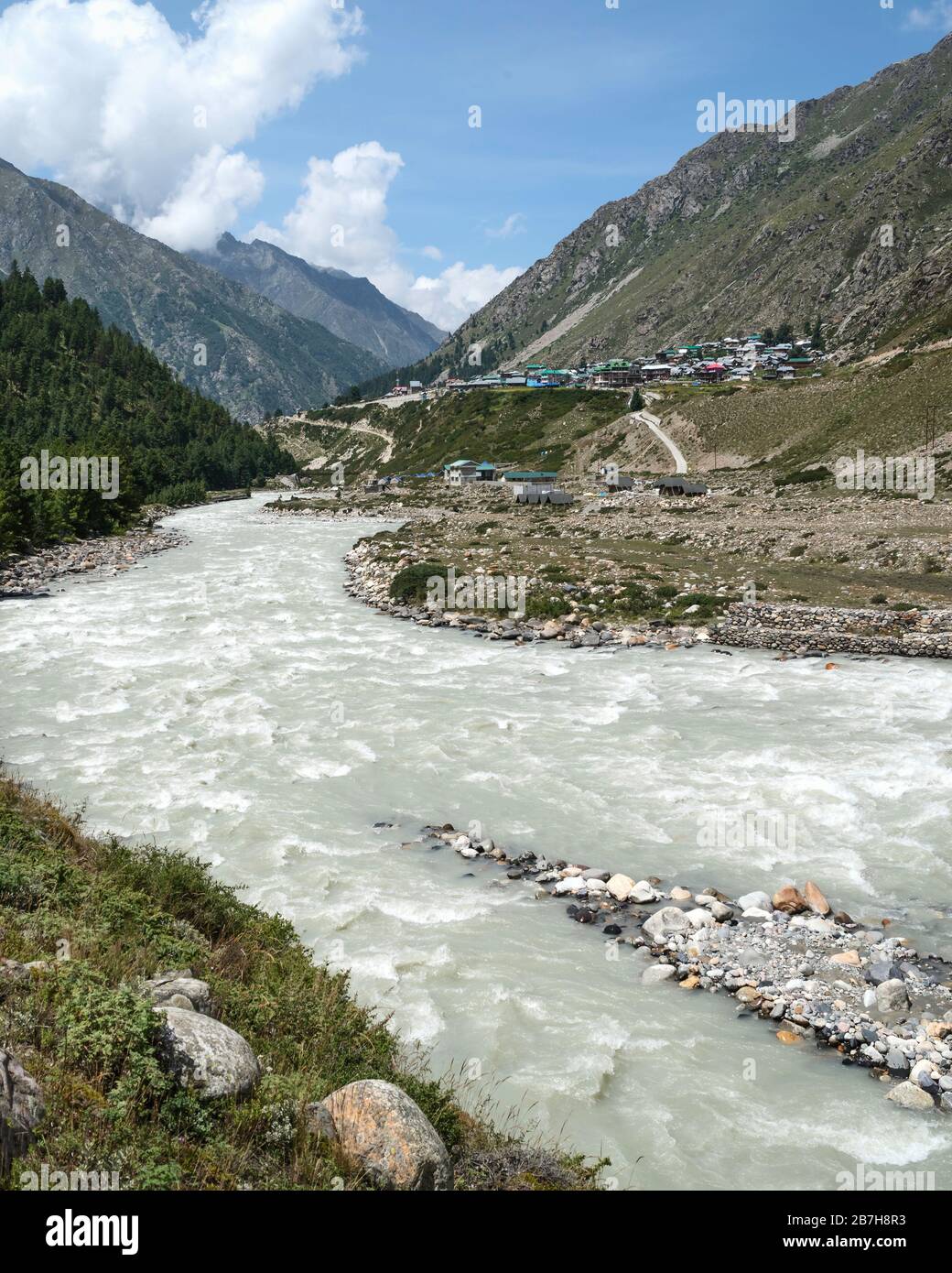 View across the Baspa river towards the rugged Himalayas and the small ...