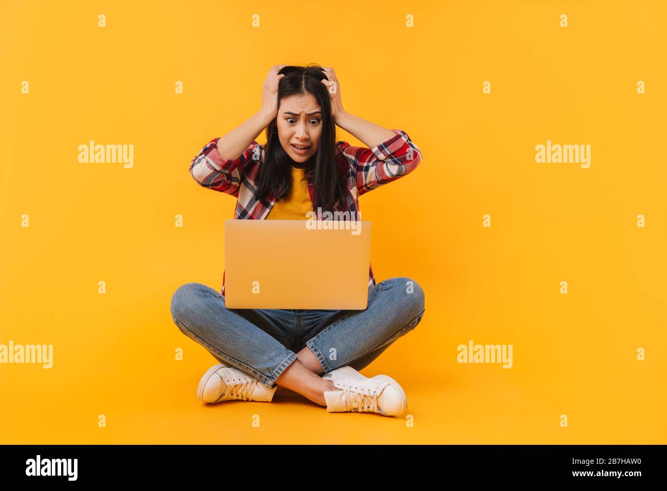 Photo of scared woman expressing shock while sitting on floor with ...