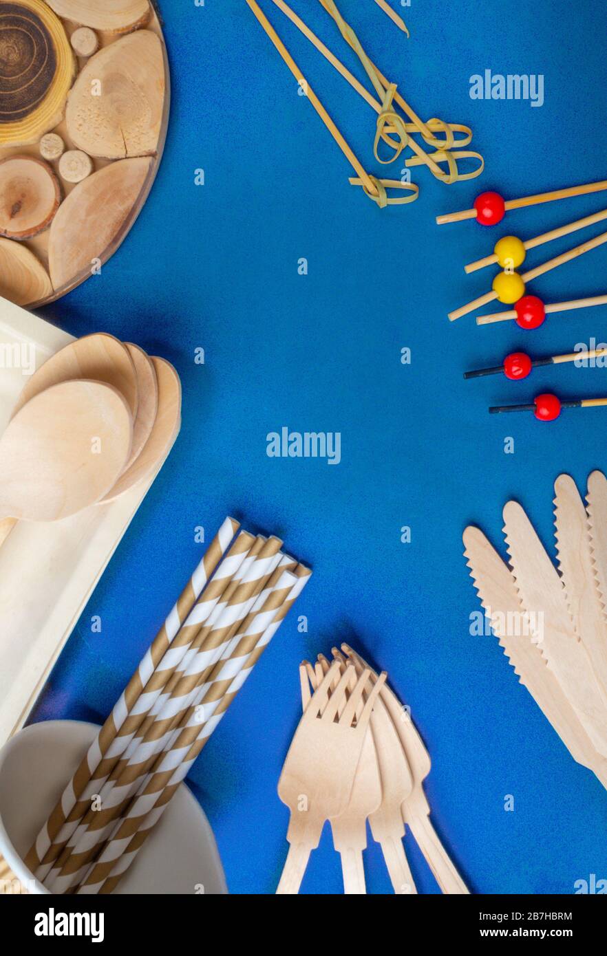 Disposable wooden cutlery on blue color background, drink tube, spoon ...