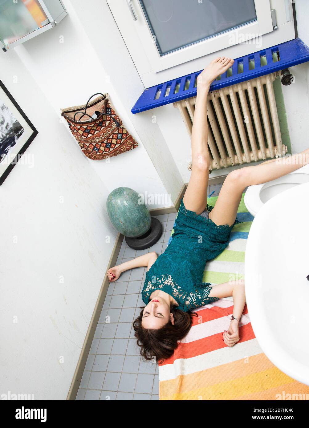 Woman passed out on the bathroom floor, green dress Stock Photo - Alamy