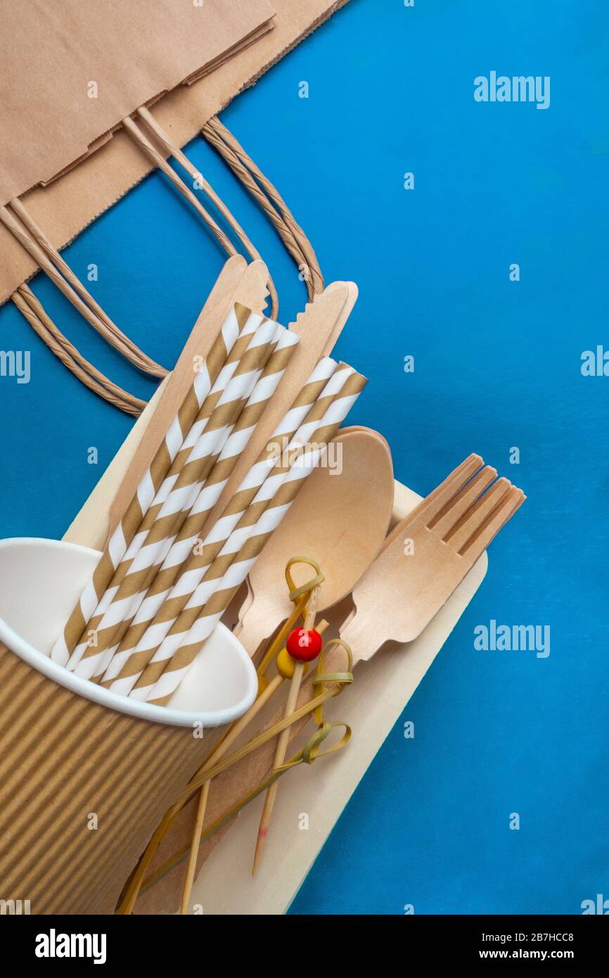 Disposable wooden cutlery on blue color background, drink tube, spoon ...